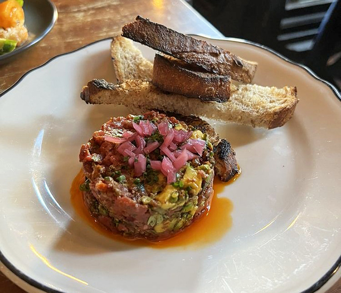 Beef tartare artfully plated with pickled onions shows the kitchen's sophisticated culinary skills. 