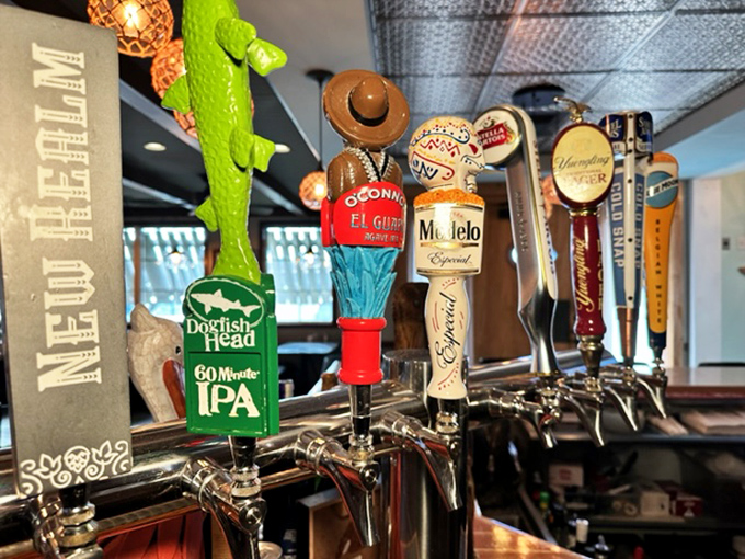 Beer taps standing at attention like colorful sentries. Each handle promises a different journey for your taste buds.
