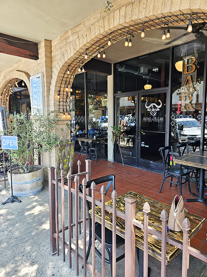 Bistro di Bufala's inviting patio beckons with Mediterranean charm, where string lights and brick archways set the stage for pasta-twirling perfection.