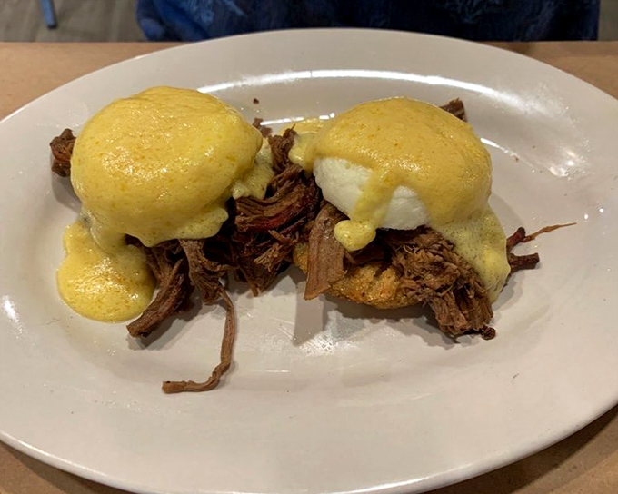 BBQ reimagined: pulled pork Benedict with hollandaise creates a breakfast-meets-dinner masterpiece that would make both pitmasters and French chefs applaud.