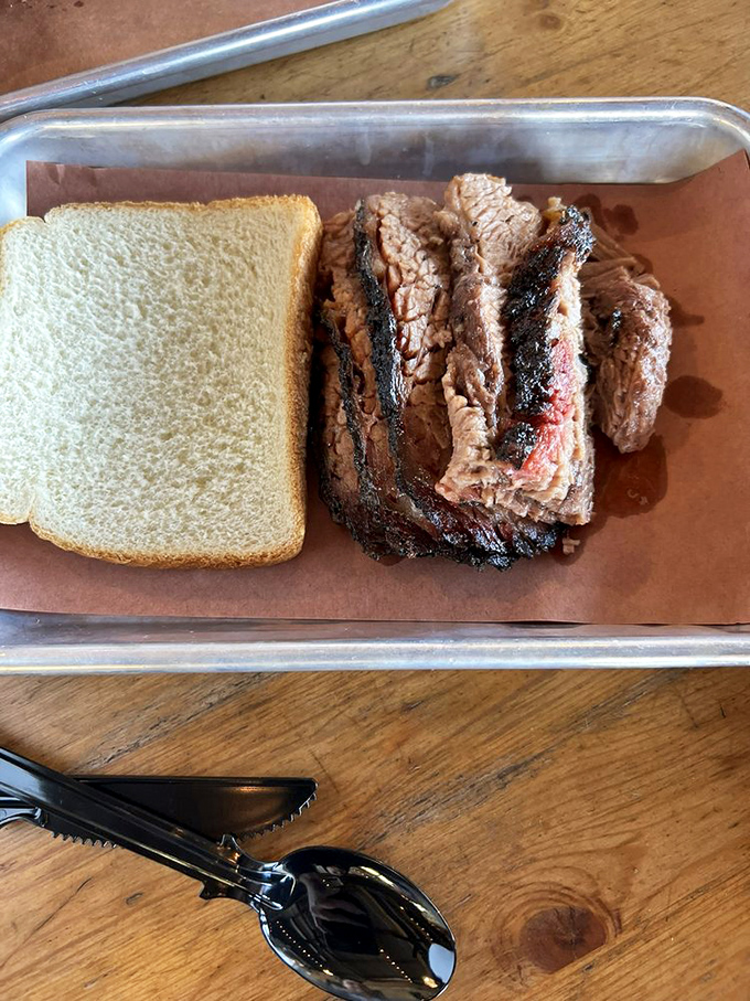 Brisket so tender it barely needs the knife beside it. The simple white bread stands ready for its supporting role in barbecue perfection.