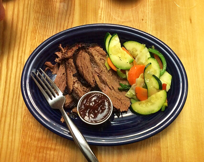 Slices of pink-centered brisket with a side of fresh vegetables&mdash;a plate that whispers "I've been smoking all day" with pride.