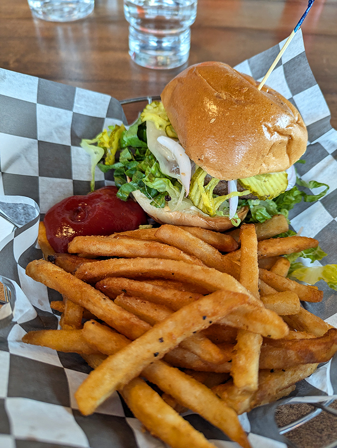 The burger: a handheld masterpiece of beef, fresh toppings, and architectural integrity, escorted by golden fries standing at attention.