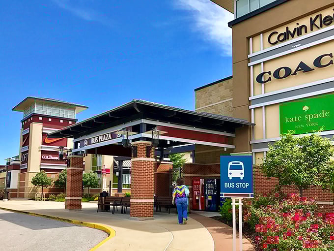 The bus stop and Nike outlet&mdash;where public transportation meets private indulgence. That splash of red flowers adds a touch of whimsy to retail therapy.