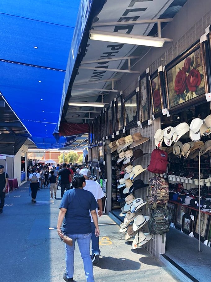 A sea of cowboy hats and framed artwork line the walkway as shoppers stroll through this desert bazaar of possibilities.