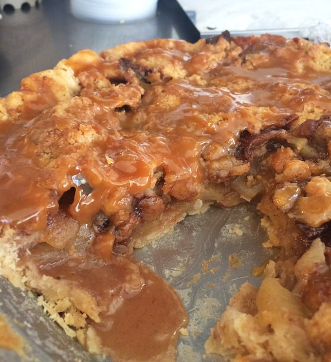 A slice of apple pie that's halfway to heaven &ndash; brown sugar crumble topping cascading into cinnamon-spiced apples and buttery crust below.