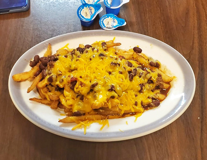 Chili cheese fries that laugh in the face of diet culture—a glorious mess of beans, beef, and melted cheese that demands to be shared but rarely is.