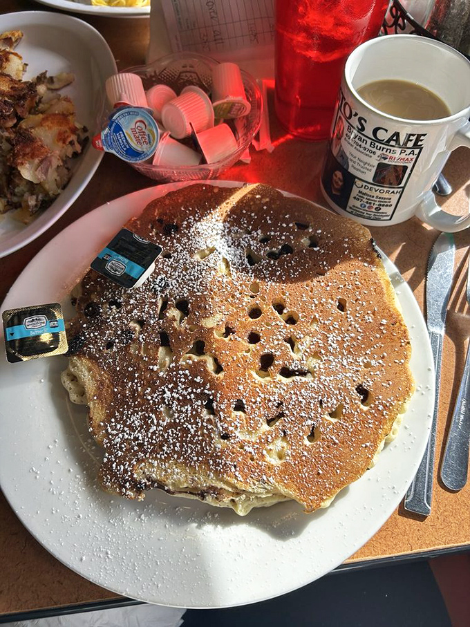A pancake so large it needs its own zip code, dusted with powdered sugar and ready to soak up both syrup and conversation.