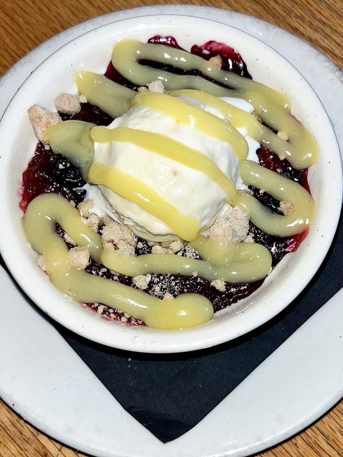 A berry cobbler that strikes the perfect balance between homestyle comfort and restaurant finesse, crowned with ice cream melting into warm fruit like a sweet surrender.