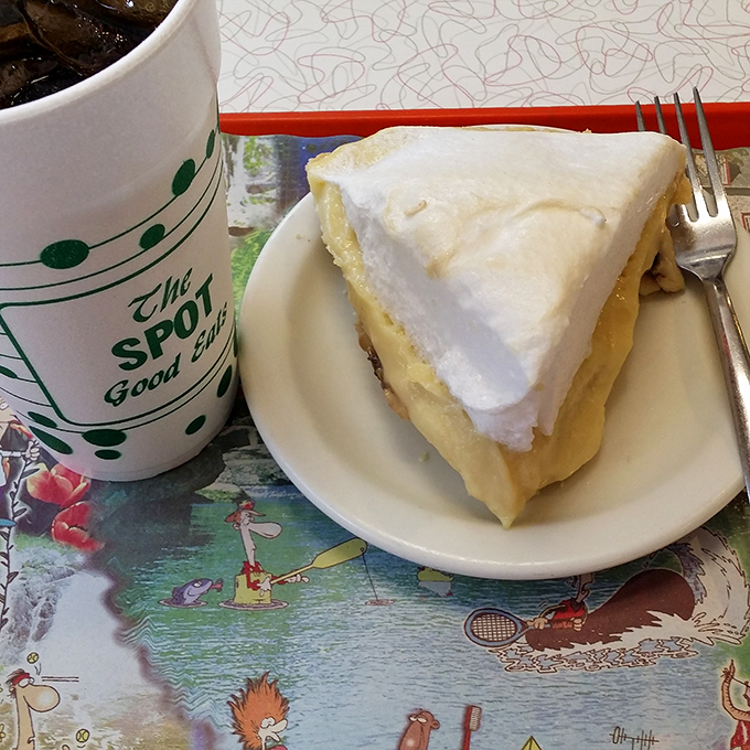 A slice of coconut cream pie with mile-high meringue sits beside a branded mug&mdash;the perfect finale to a meal that feels like coming home.