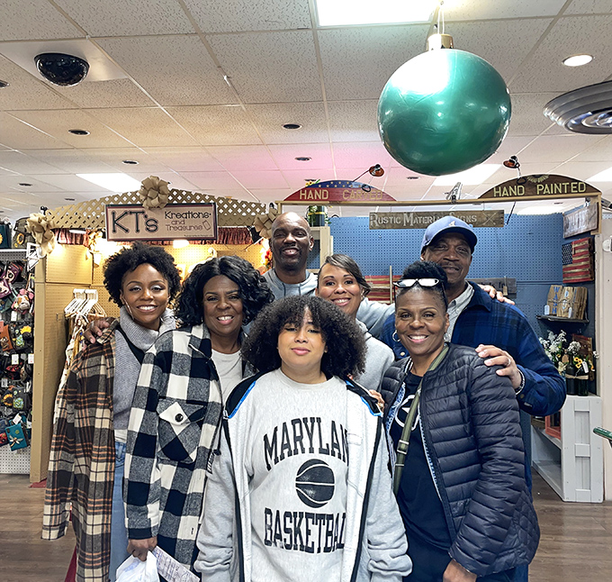 The image shows a group of people enjoying their visit to the store, sharing in the joy of discovery that makes antiquing a wonderful social experience.