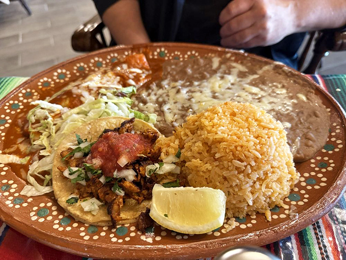 A perfect trifecta of taco, rice, and beans on a decorative plate &ndash; simple, authentic flavors that remind you why Mexican cuisine conquered America's heart.