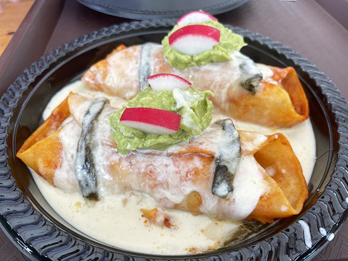 These enchiladas swim in a creamy sea of flavor, topped with fresh radish and lettuce. A beautiful balance of richness and brightness.