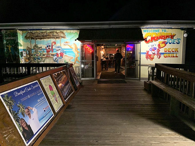 By night, the entrance transforms into a neon-lit beacon for hungry souls seeking seafood salvation at the end of the pier.