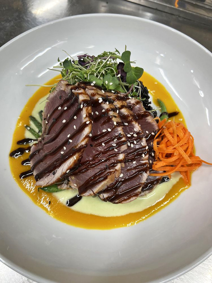 Seared ahi tuna sliced to reveal a perfect ruby center, drizzled with sauces that dance between sweet, savory, and umami in perfect harmony.