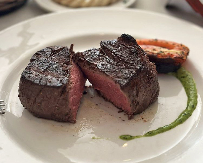 The holy grail of steakhouse experiences: a perfectly cooked filet mignon, sliced to reveal the rosy interior that beef aficionados dream about.