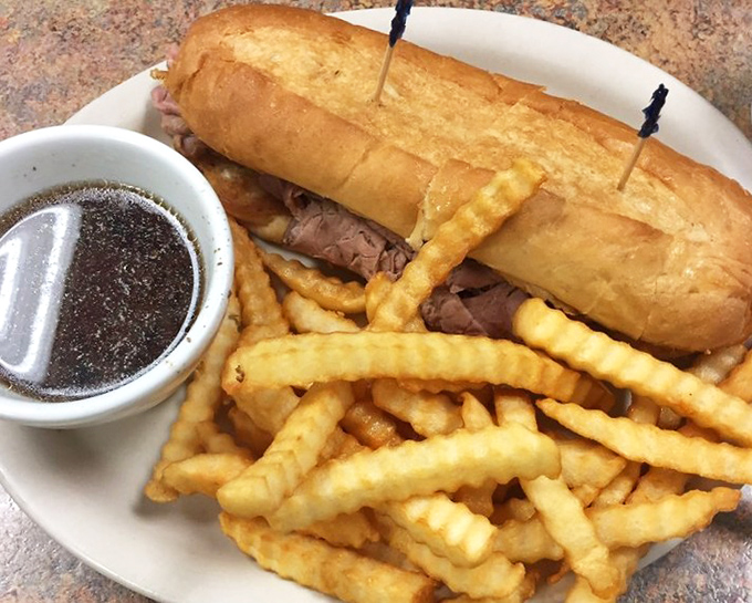 A French Dip sandwich with enough au jus to satisfy even the most enthusiastic dipper, surrounded by fries that demand to be finished.