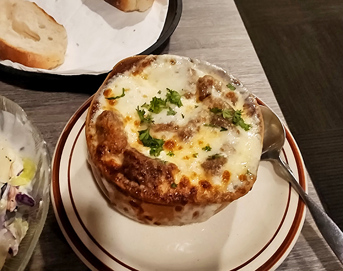 French onion soup that bubbles with promise under a golden cheese canopy. Breaking through the top is like discovering buried treasure&mdash;if treasure were made of cheese and onions.