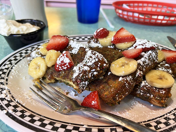 This French toast has clearly been living its best life, dressed up with fresh fruit and powdered sugar like it's heading to breakfast prom.