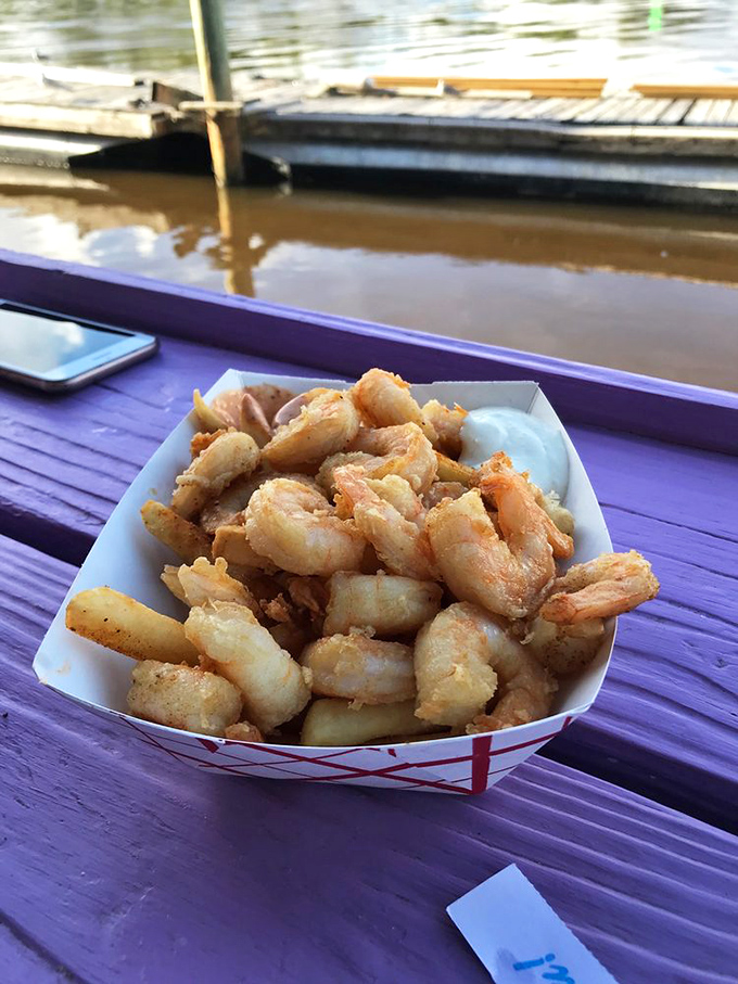 Fried shrimp piled high in a basket, enjoyed with a waterfront view. This is what vacation tastes like, even if you're just on lunch break.