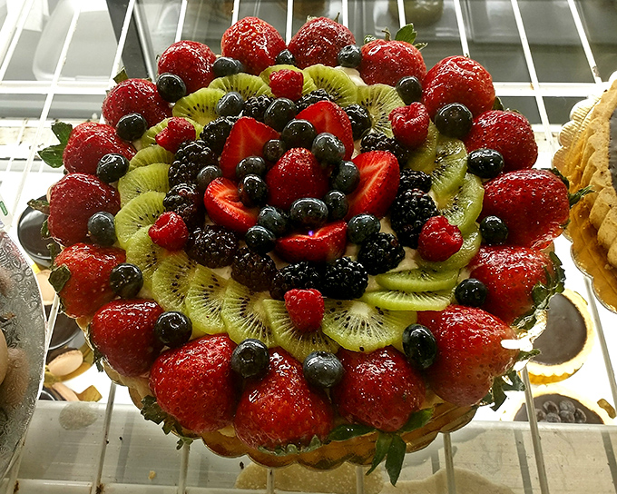 A fruit tart arranged with the precision of a Swiss watchmaker and the colors of a sunset.