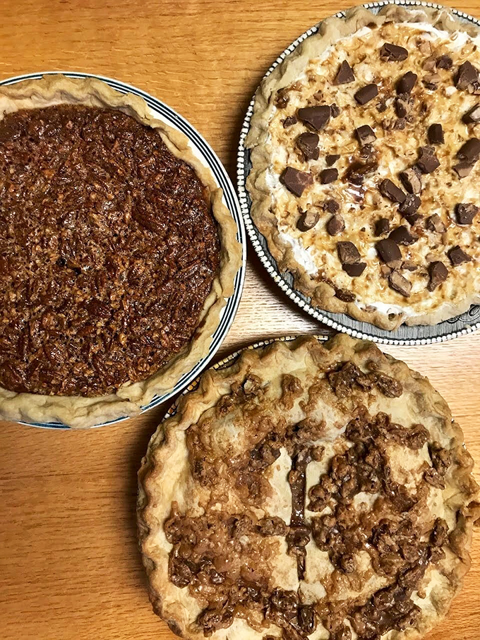 The pie trifecta—pecan, chocolate chip, and what appears to be apple. Homemade desserts that remind you why people used to put pies on windowsills.