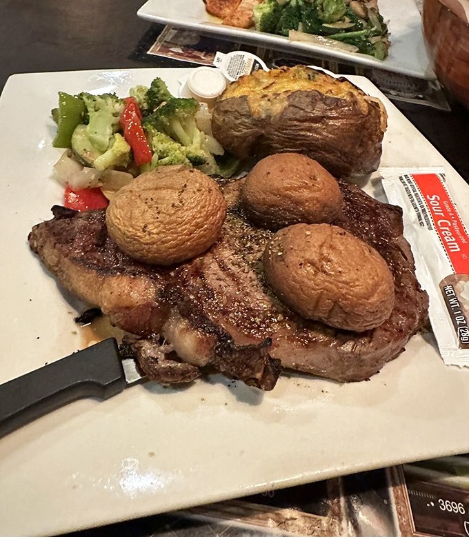 A steak that's clearly been introduced to proper seasoning. Those mushrooms and that baked potato are the supporting actors in this meaty drama.