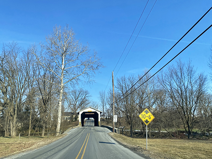 The approach tells a story of anticipation. That yellow clearance sign is both warning and invitation to slow down and appreciate what lies ahead.