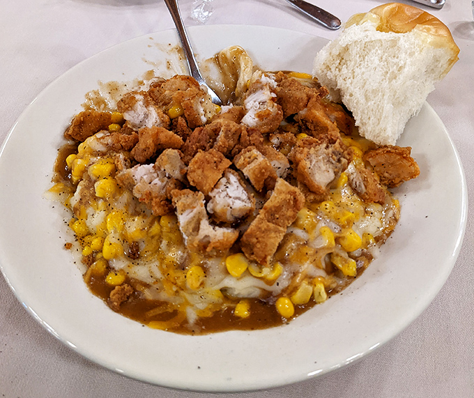 A bowl of pure Midwestern soul &ndash; creamy mashed potatoes topped with crispy chicken and sweet corn. Spoons were invented for moments like this.