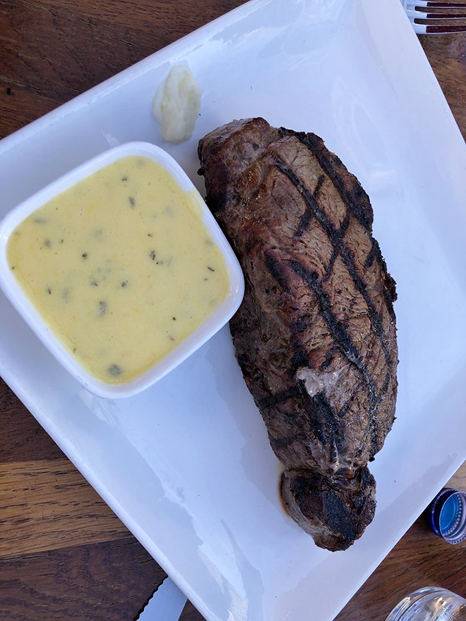 The New York strip, presented with quiet confidence, accompanied by a sauce that doesn't hide the meat's inherent excellence.