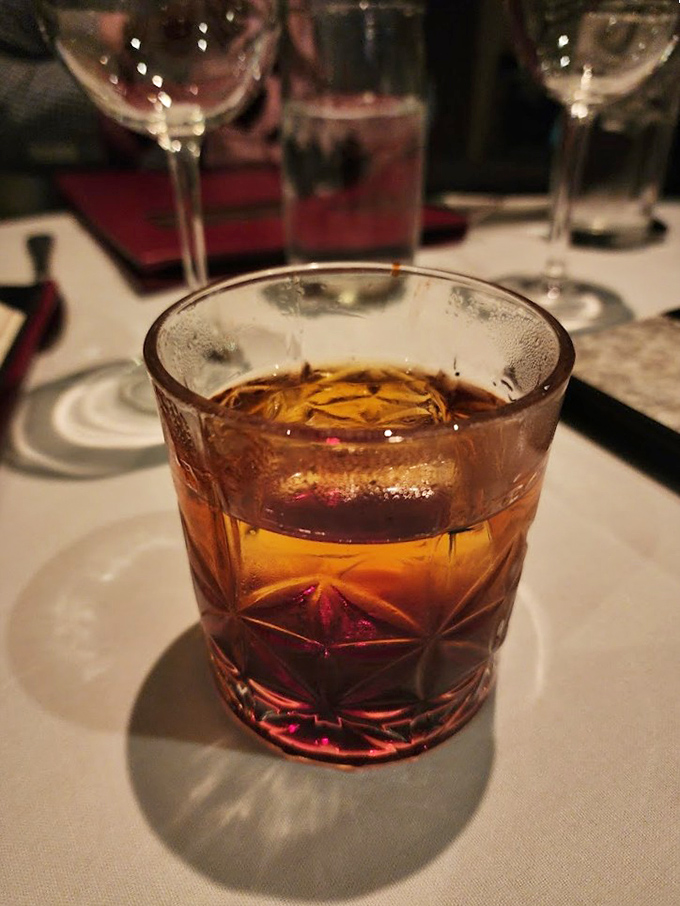 This Negroni sits in its cut crystal glass like liquid amber, promising conversations that get better with each sophisticated sip.