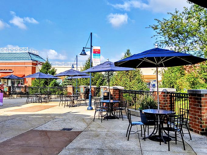 Outdoor dining areas provide a civilized respite from the shopping frenzy. Blue umbrellas shield weary bargain hunters from both sun and buyer's remorse.