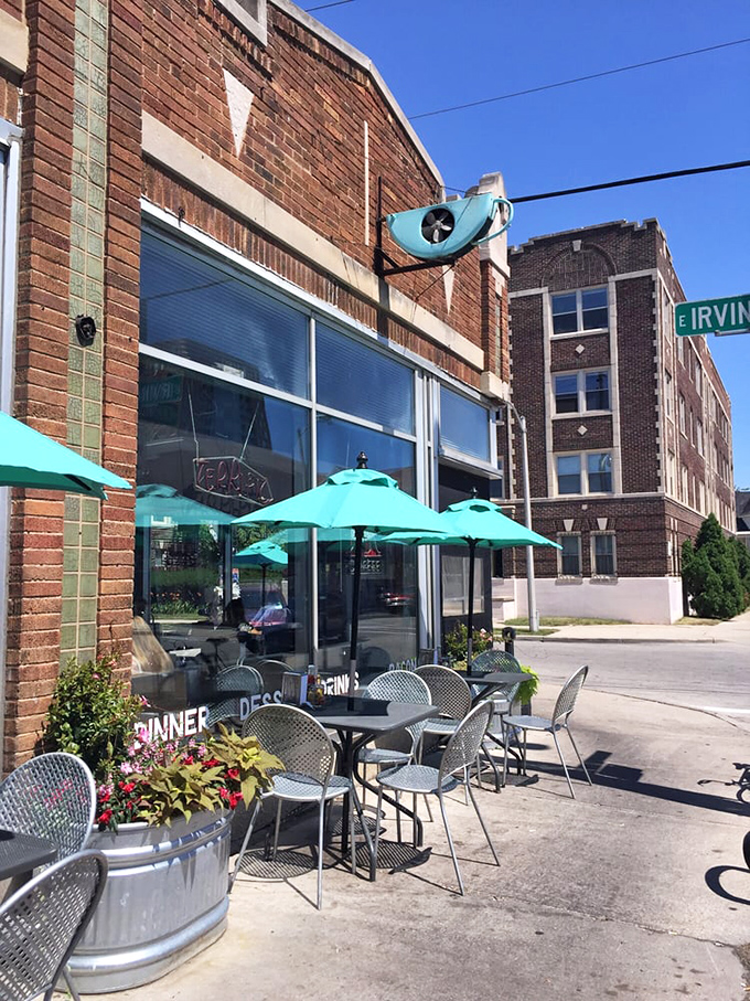 Sidewalk seating under turquoise umbrellas adds a splash of color to urban concrete. Milwaukee summer perfection is captured in this quiet corner.