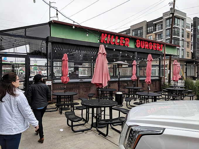 The outdoor seating area awaits under red umbrellas, promising al fresco burger bliss regardless of Atlanta's sometimes