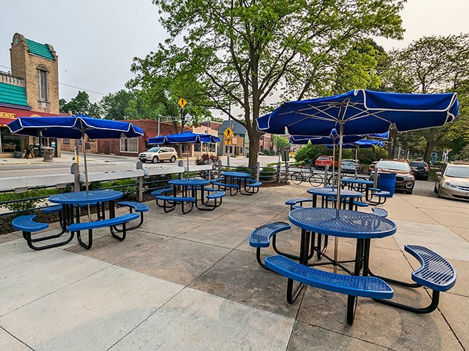 The outdoor seating area waits patiently for warmer days, blue tables ready to host everything from first dates to family reunions and spontaneous friend gatherings.