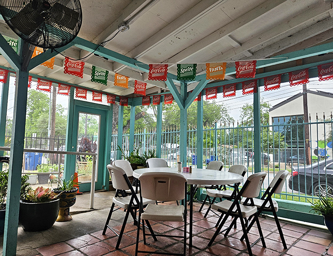 The covered patio offers a breezy Austin dining experience, where colorful soda-themed banners flutter overhead like festive flags.