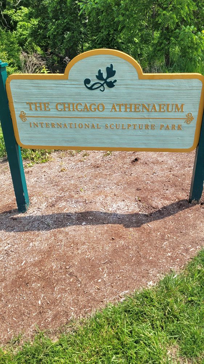 The park's unassuming entrance sign offers no spoilers for the wonderland of artistic treasures waiting just beyond the trees.