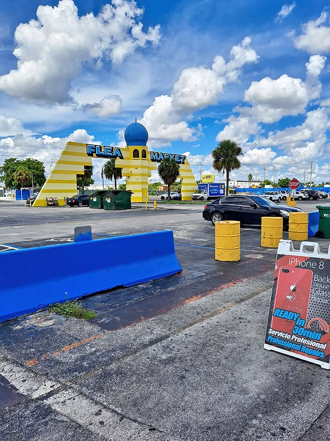 The yellow and blue archway stands guard over the parking lot like a cheerful sentinel, promising "Flea Market" adventures to all who enter.