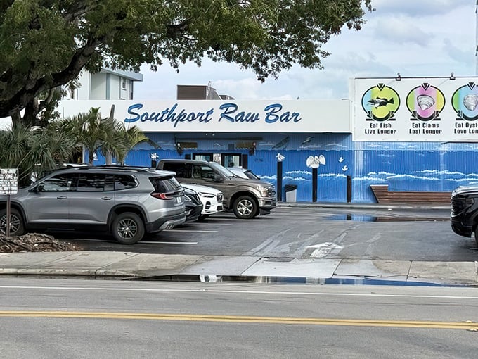 The blue exterior stands out like a delicious beacon among palm trees. That sign promises seafood salvation for those wise enough to stop.
