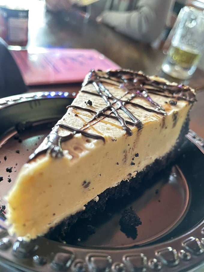 A peanut butter cheesecake that makes sharing impossible. The chocolate drizzle isn't just decoration&mdash;it's the exclamation point on a perfect meal.