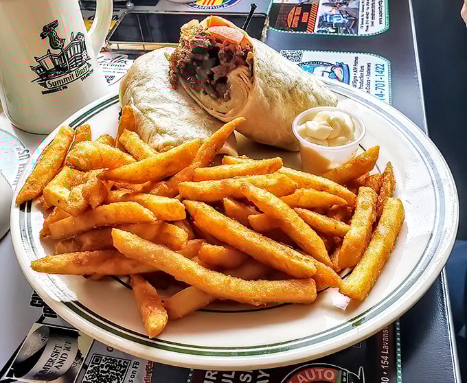 A Philly wrap surrounded by a golden fortress of perfect fries. The kind of lunch that requires a nap afterward, but you'll regret nothing.