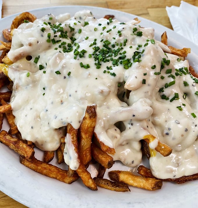 Crispy fries swimming in gravy and sprinkled with chives &ndash; proof that sometimes the messiest foods are the ones most worth the napkin investment.