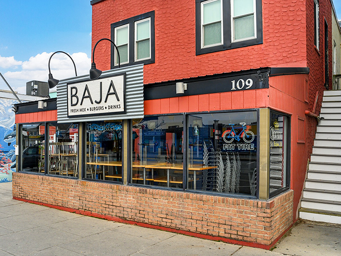 Baja's bright red exterior promises bold flavors inside, where tacos and margaritas fuel post-beach recovery sessions for sun-soaked visitors.