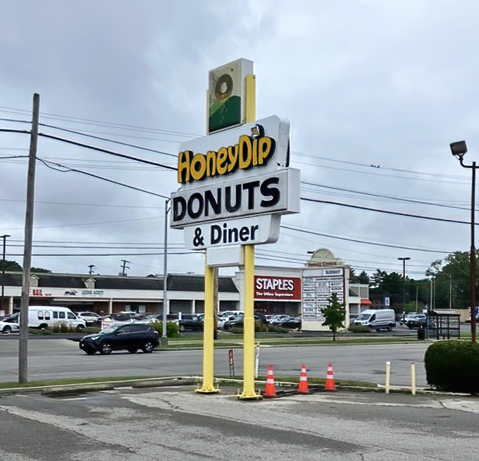 The roadside sign stands tall, a yellow beacon of breakfast hope amid shopping centers and stoplights. Follow it to happiness.