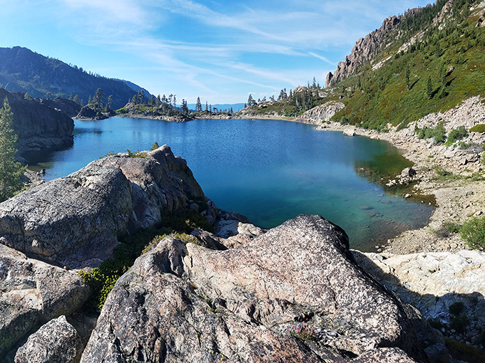 Nature's jewel box revealed. This hidden alpine lake, cradled by granite sentinels, rewards those willing to venture beyond the beaten path.