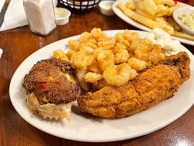 The seafood platter that launched a thousand return visits—golden fried treasures from the sea alongside what might be the world's most perfect crab cake.