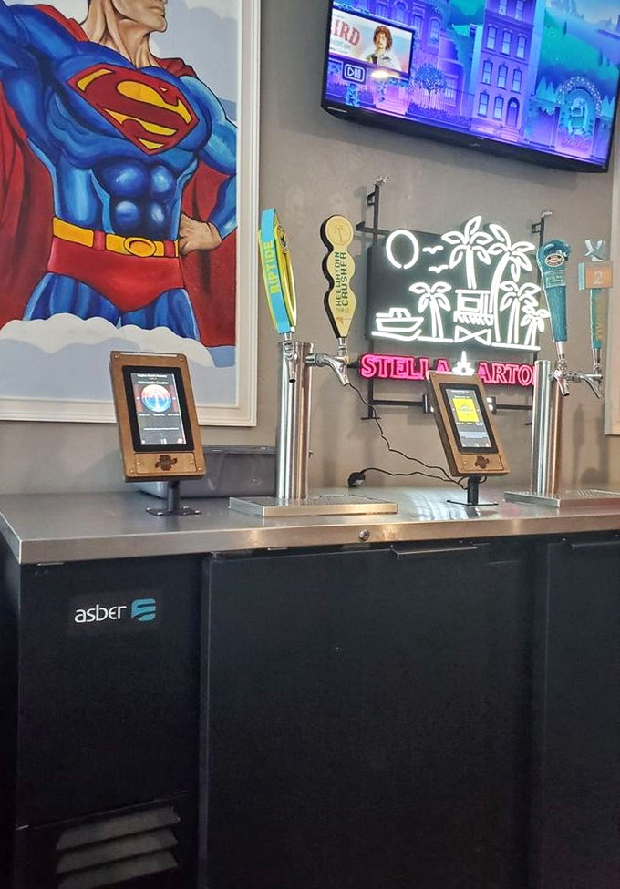 Self-serve beer taps stand ready beneath Superman's watchful gaze—because even superheroes need a good burger and brew.