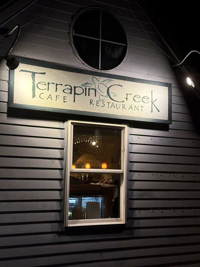 As night falls, the blue cottage glows with promise. Like a lighthouse for hungry travelers, it beckons with the warm light of culinary excellence.