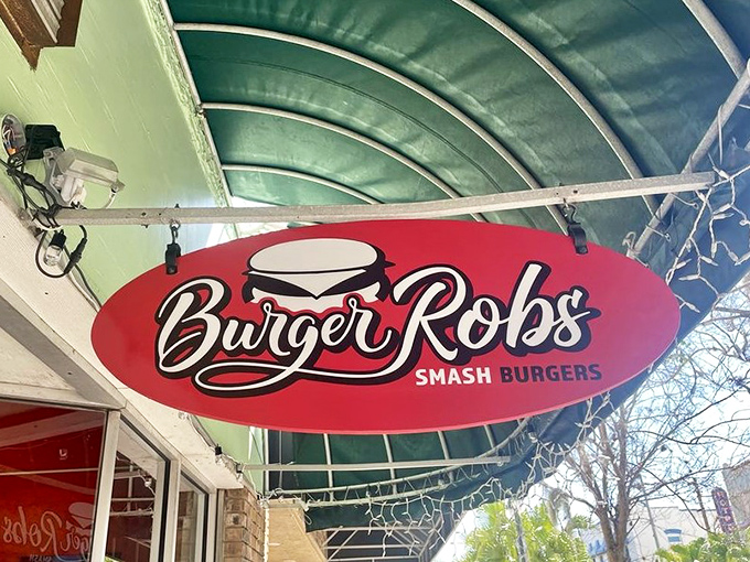 The sign swings gently in the Florida breeze, like a red oval lighthouse guiding hungry souls to smashed burger salvation.