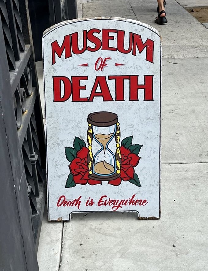 Street signage featuring an hourglass and roses reminds passersby that beauty and mortality are forever intertwined in life.